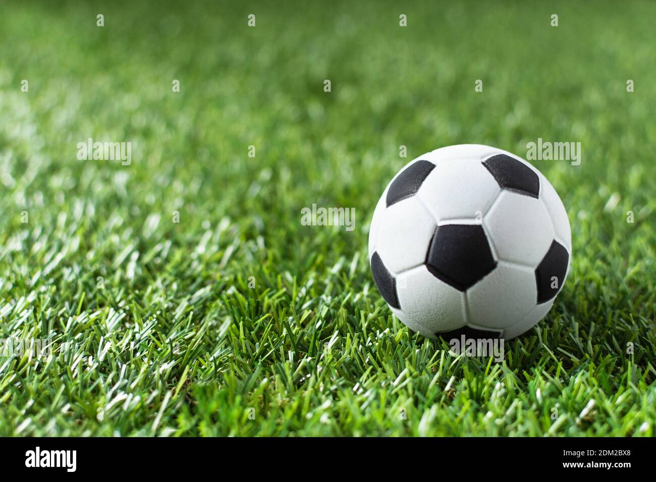 Traditional soccer ball on grass soccer field in a sun rays. Football ...