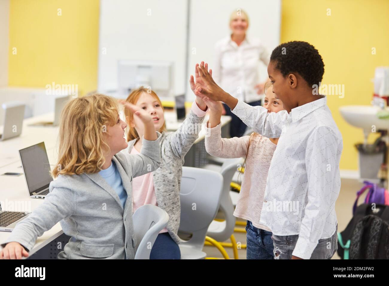 Children Giving High-five In Classroom At School Stock Photo - Alamy