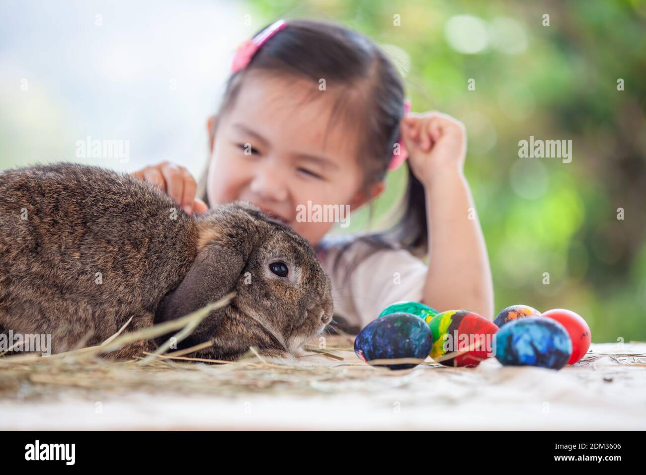 Cute Girl Touching Rabbit With Easter Eggs On Table Outdoors Stock ...
