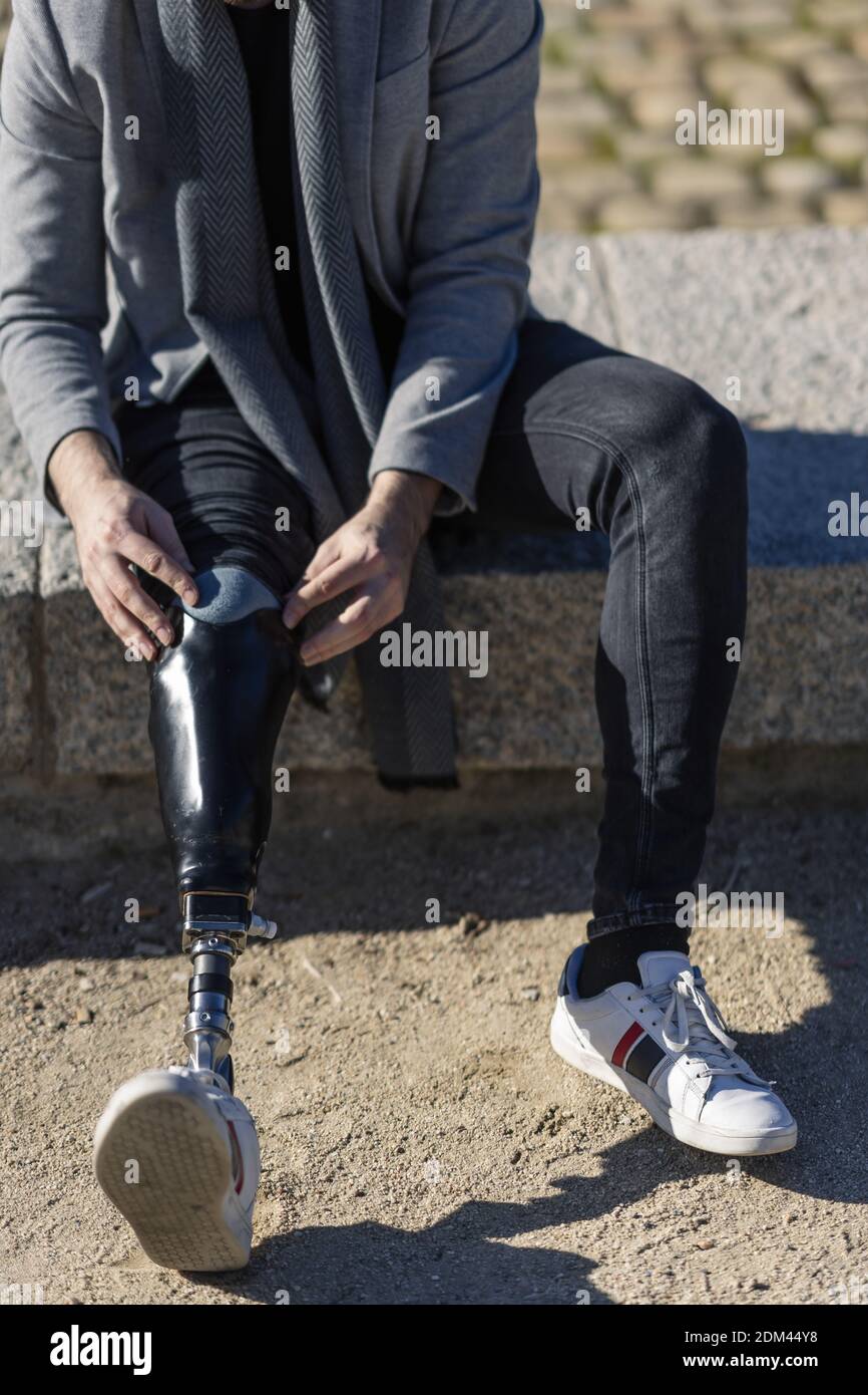 A closeup shot of a disabled young man with foot prosthesis sitting ...