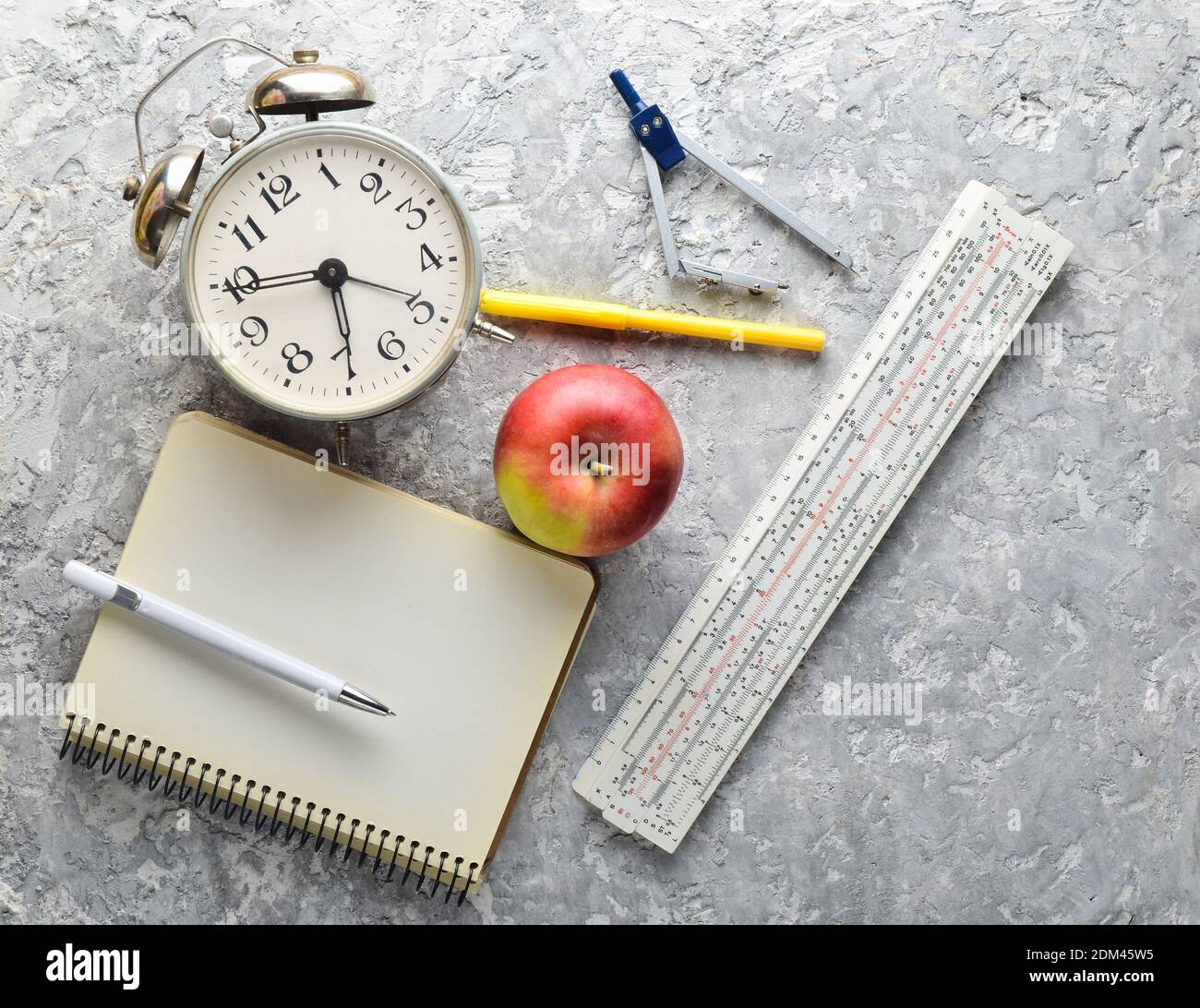 Education equipment. Alarm clock, notepad, ruler, apple, pen, compasses ...