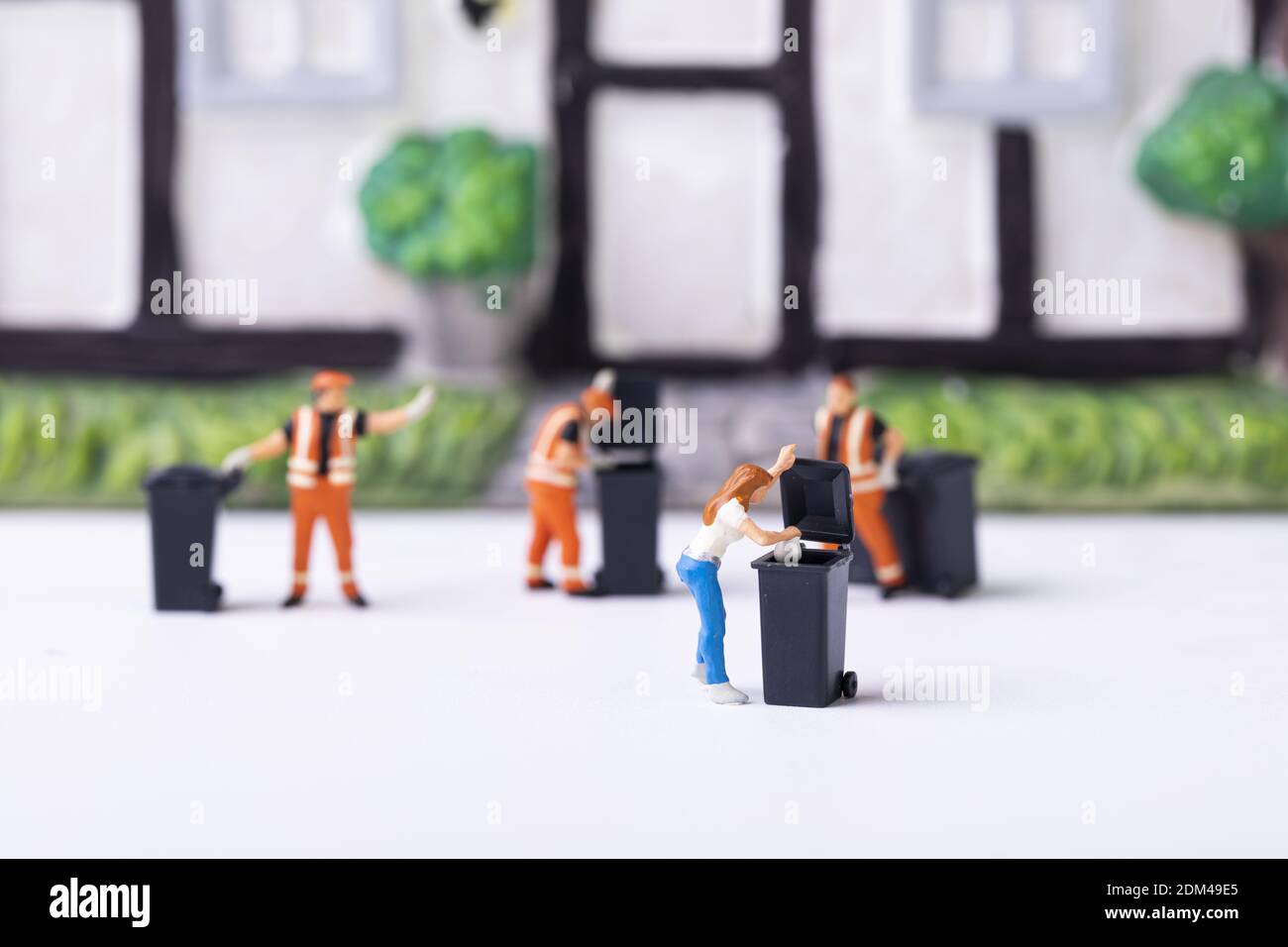 A selective focus shot of a lady throwing garbage and waste collector ...