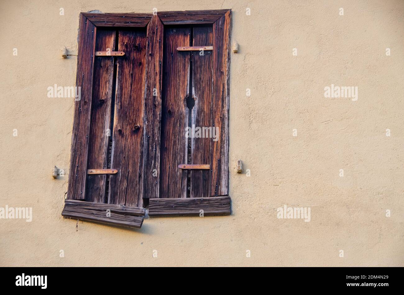 Window with old closed shutters in bright house wall. Copy Space for ...