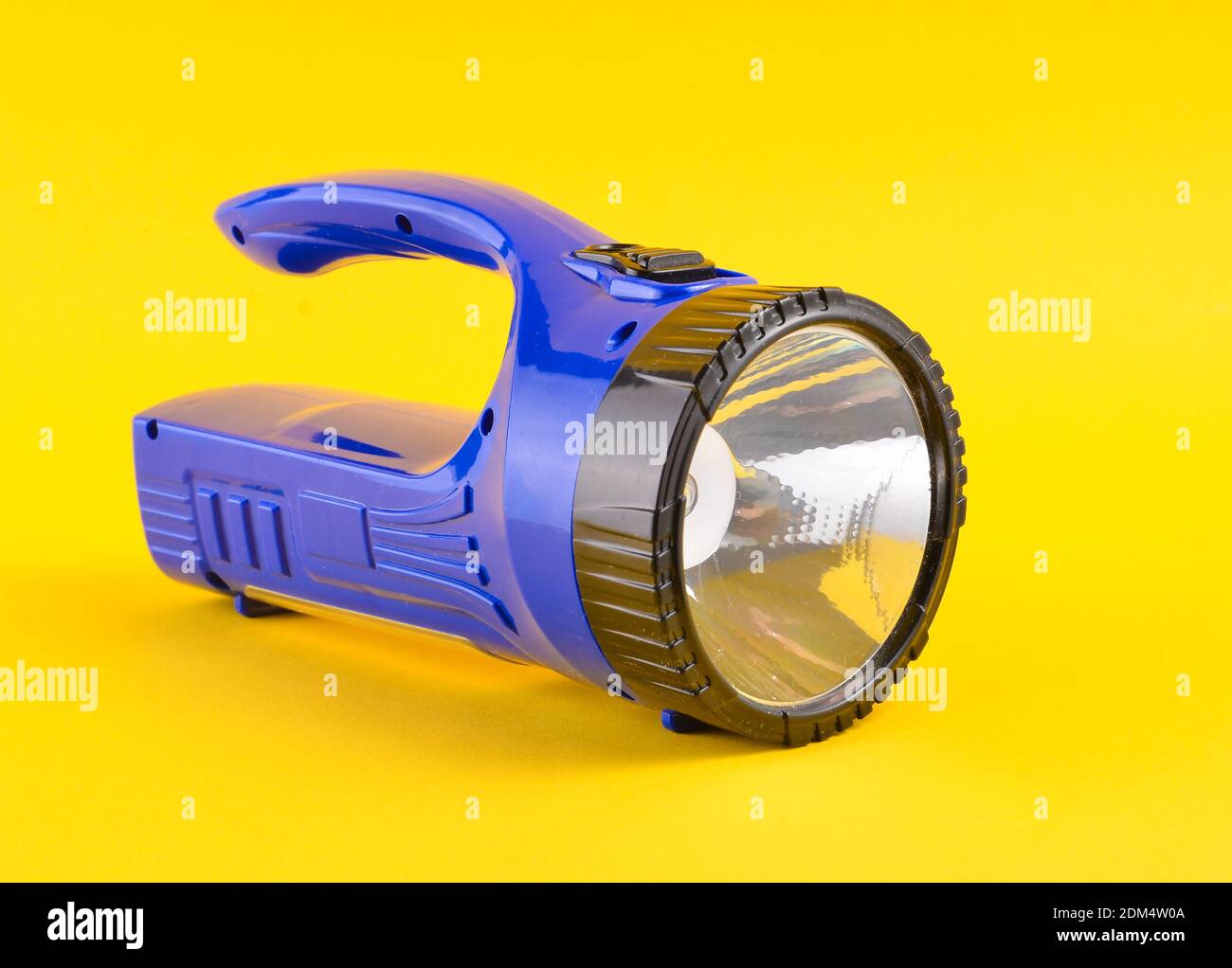 Blue flashlight isolated on a yellow background Stock Photo - Alamy