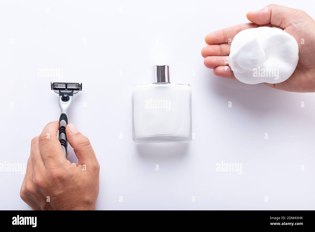 Hands holding razor blade and shaving foam, with after shave isolated ...