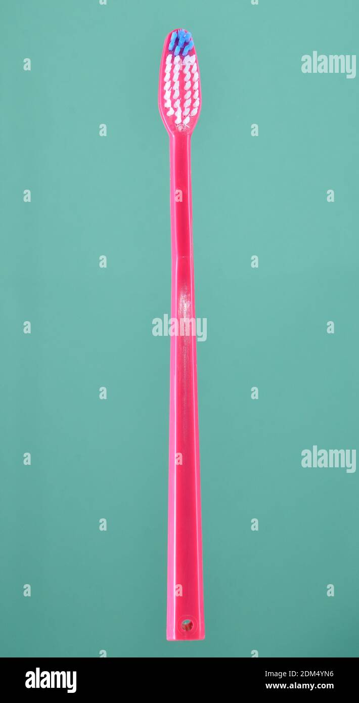 Pink toothbrush on mint color pastel background Stock Photo - Alamy