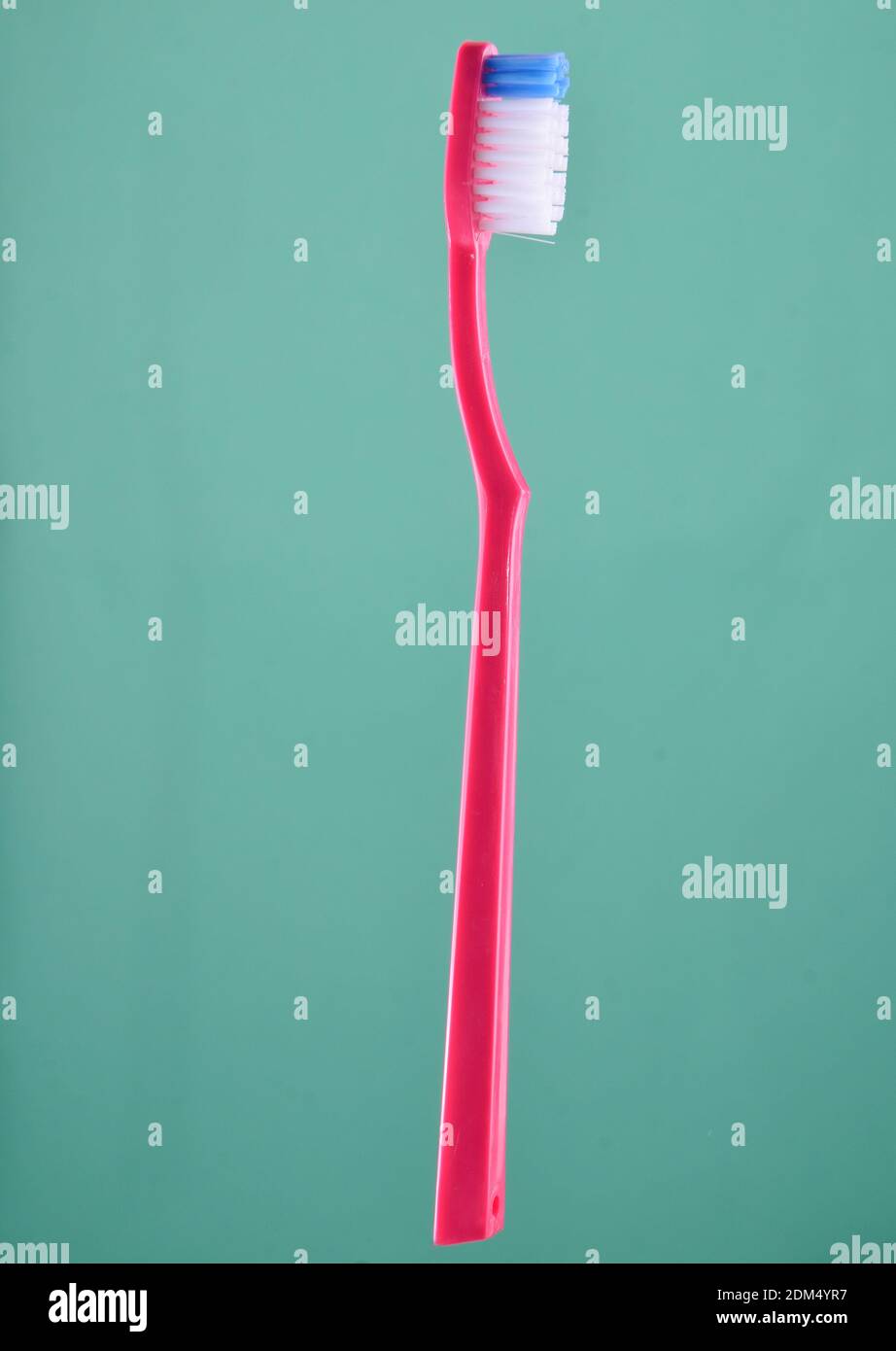 Pink toothbrush on mint color pastel background Stock Photo - Alamy