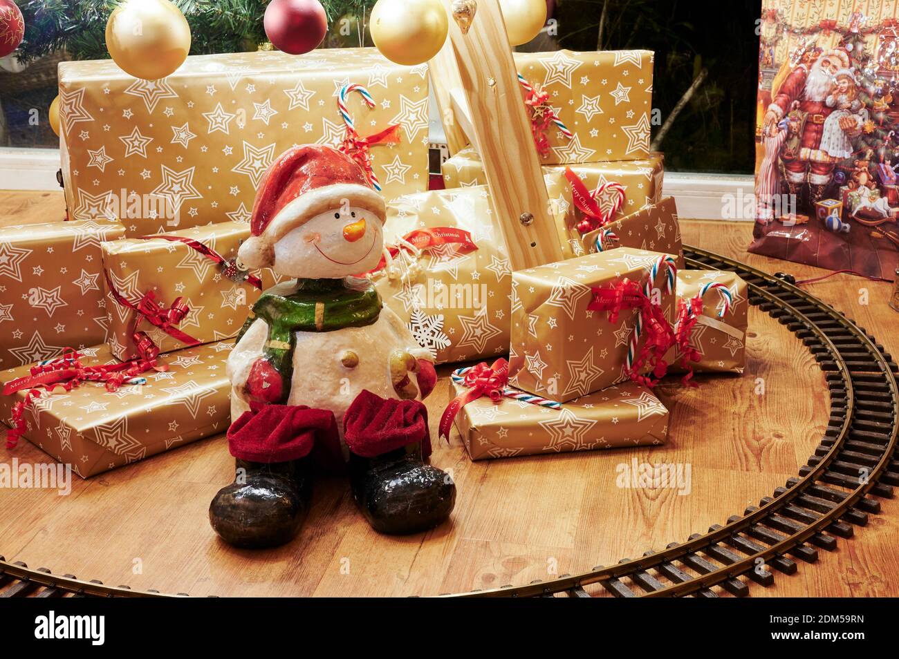A snowman as a Christmas decoration with many gift packages in the ...