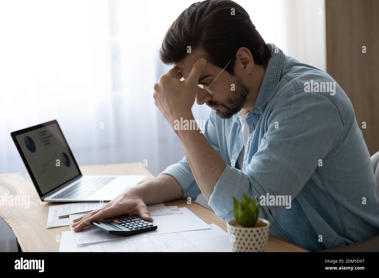 Pensive young man calculate household expenses thinking Stock Photo - Alamy