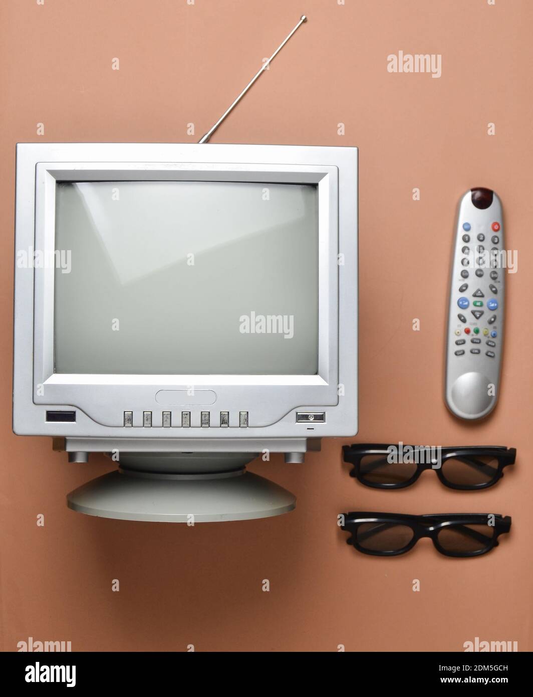 Retro tube TV, 3d glasses and remote control on a brown background. Top ...