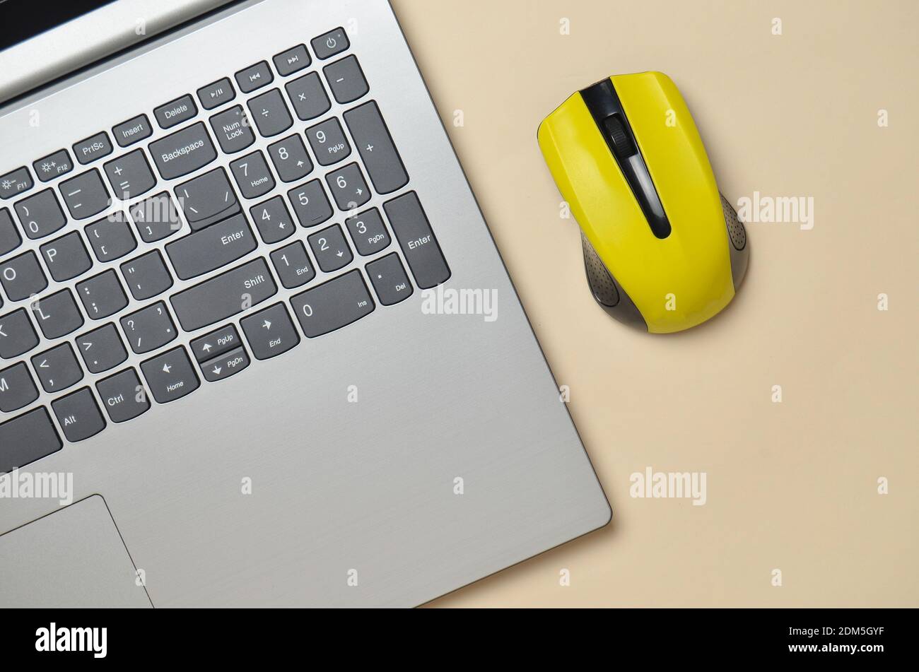 Modern laptop, wireless mouse on a yellow pastel background, minimalism ...