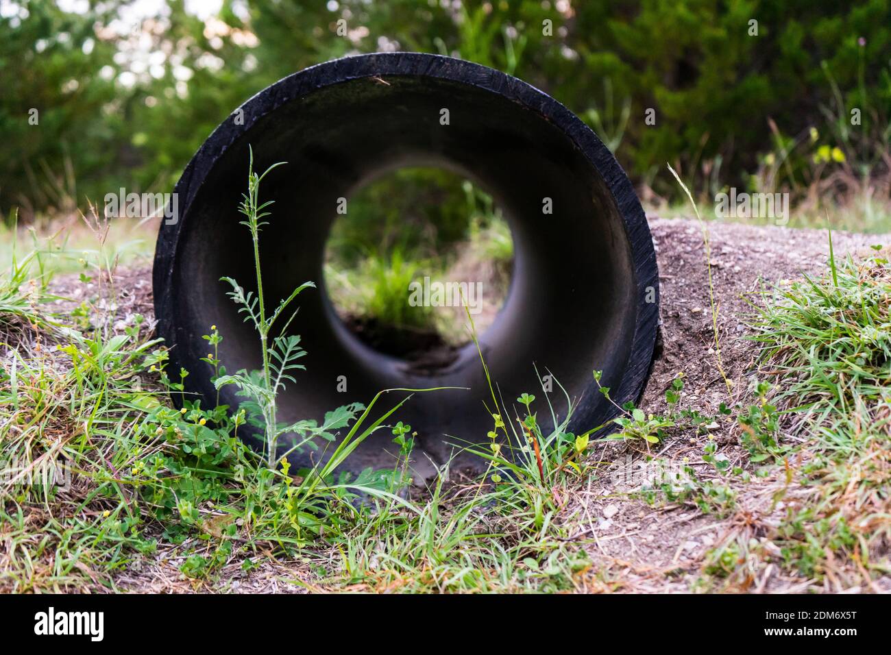 A view through a tube laying on the ground in soft focus Stock Photo ...