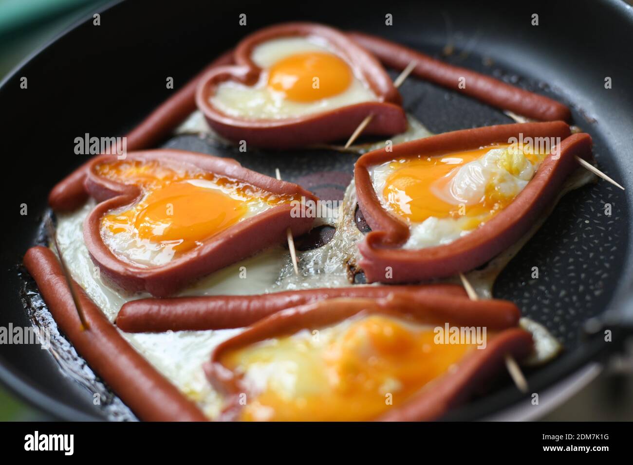 Heart shaped fried eggs in sausages in a frying pan Stock Photo - Alamy