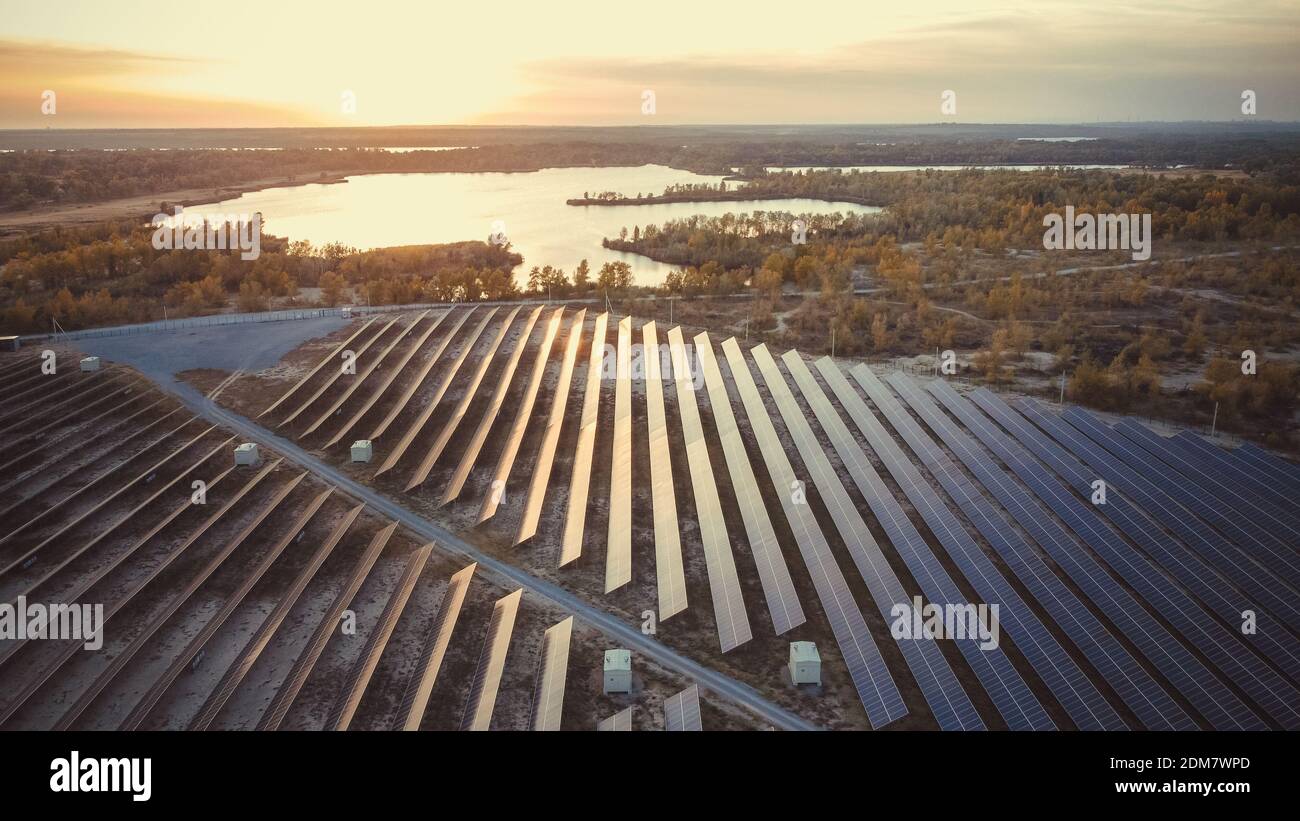 Solar panel station with reflection of sun and river on background. ECO ...