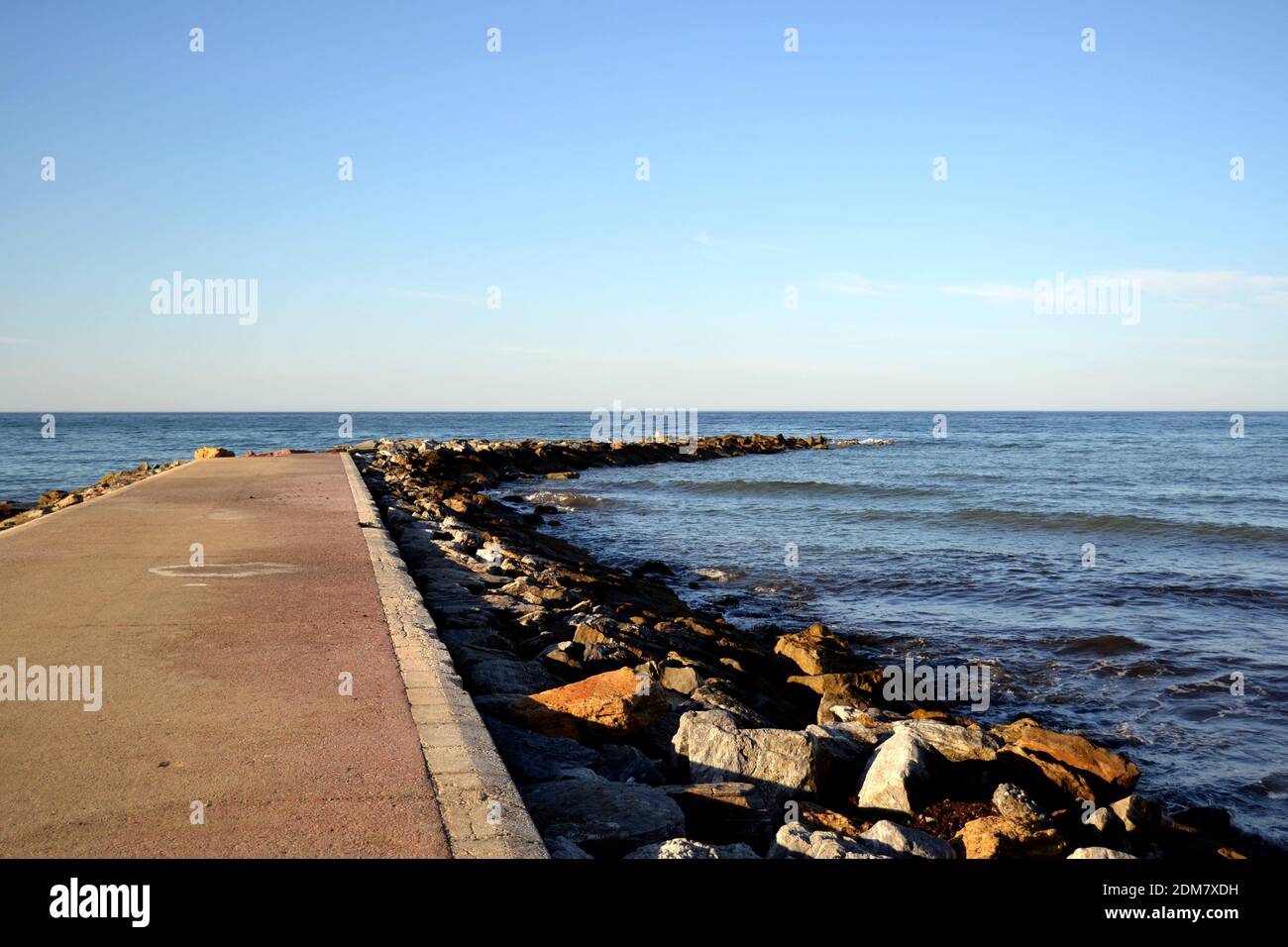 A spur on the beach made with stones to contain the blue sea Stock ...