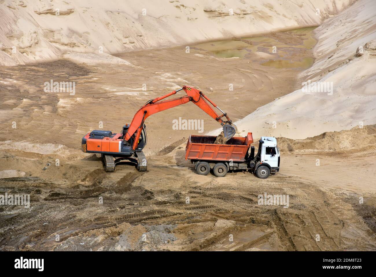 Excavator load the sand to the heavy dump truck in the open-pit. Heavy ...