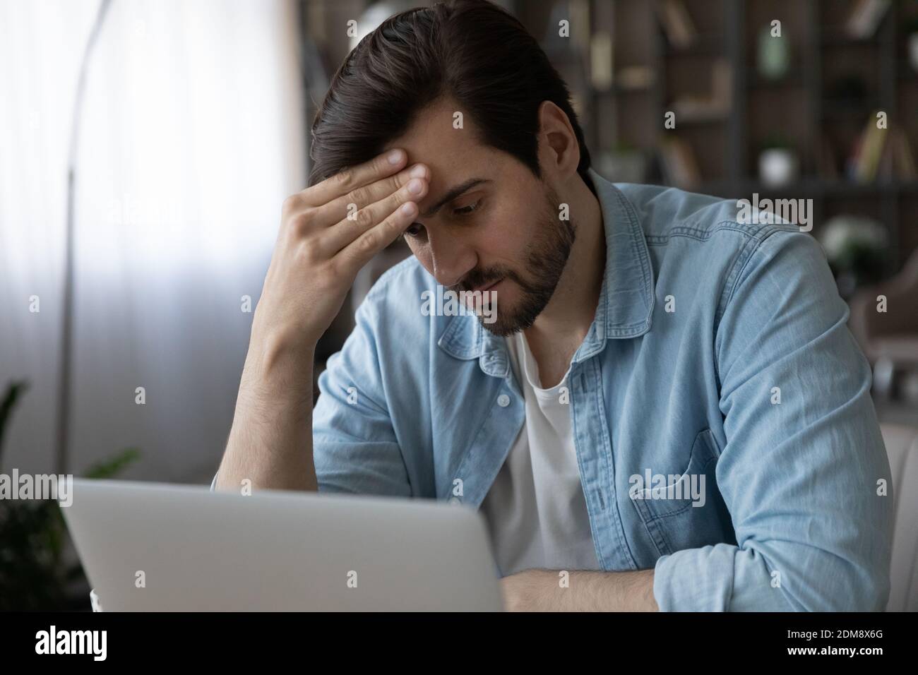Pensive man look at laptop screen thinking Stock Photo - Alamy