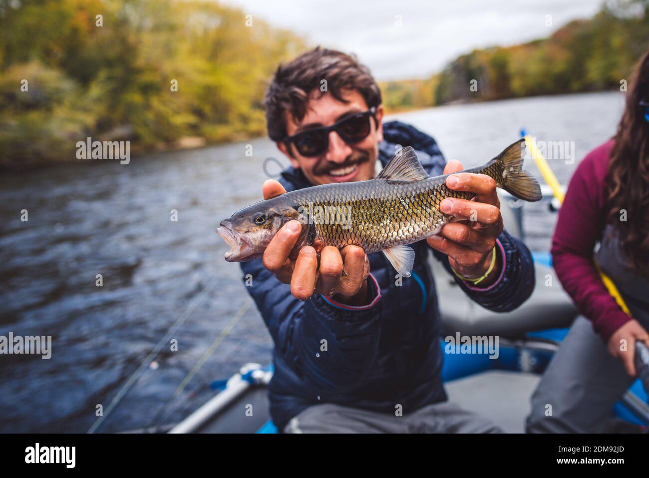Man holds chub fish out in front of him in a boat Stock Photo - Alamy