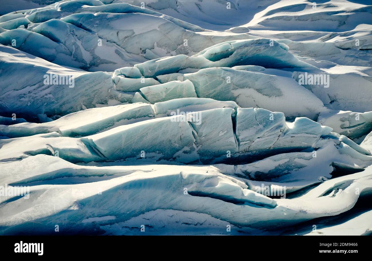 Layers of cracked ice covered with white snow in mountains in winter in ...