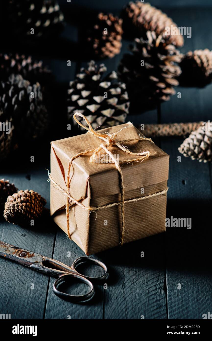 Package wrapped in kraft paper and tied with rope on black wooden ...