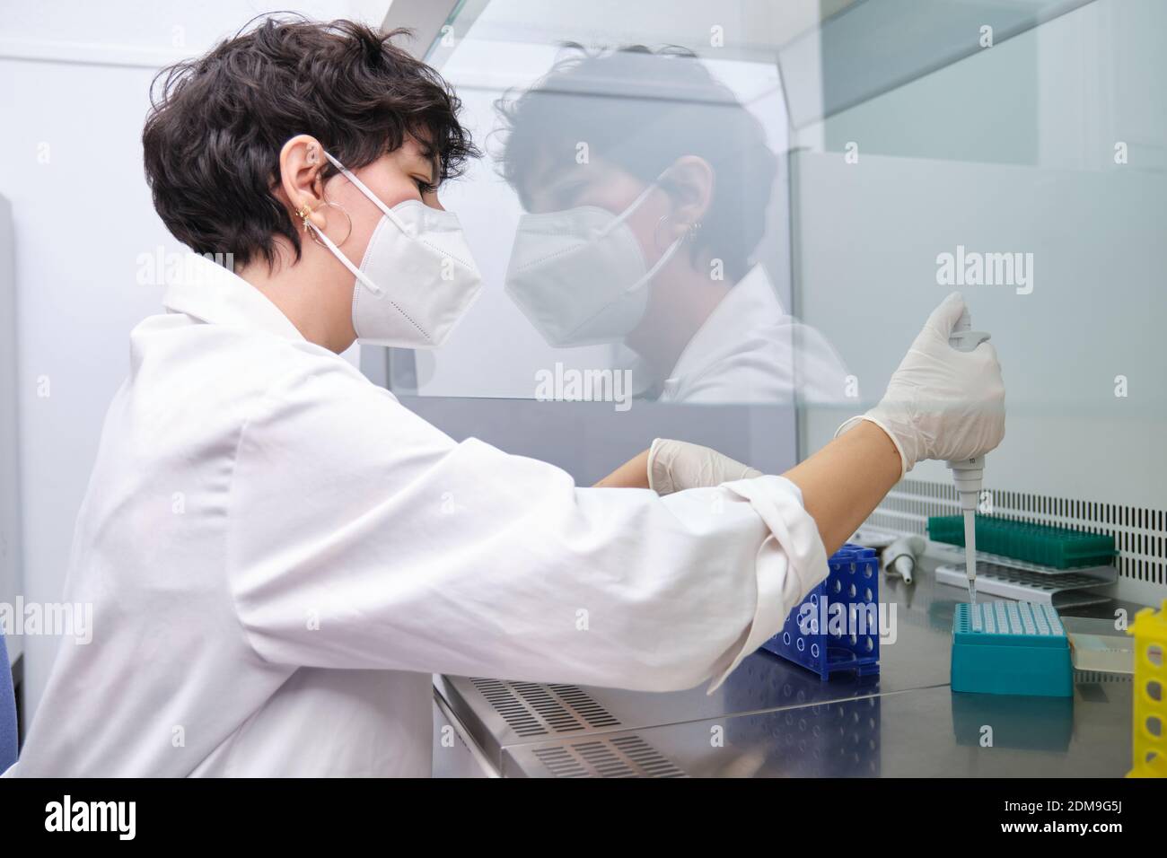 Young female scientist wearing face mask during an experiment in a ...