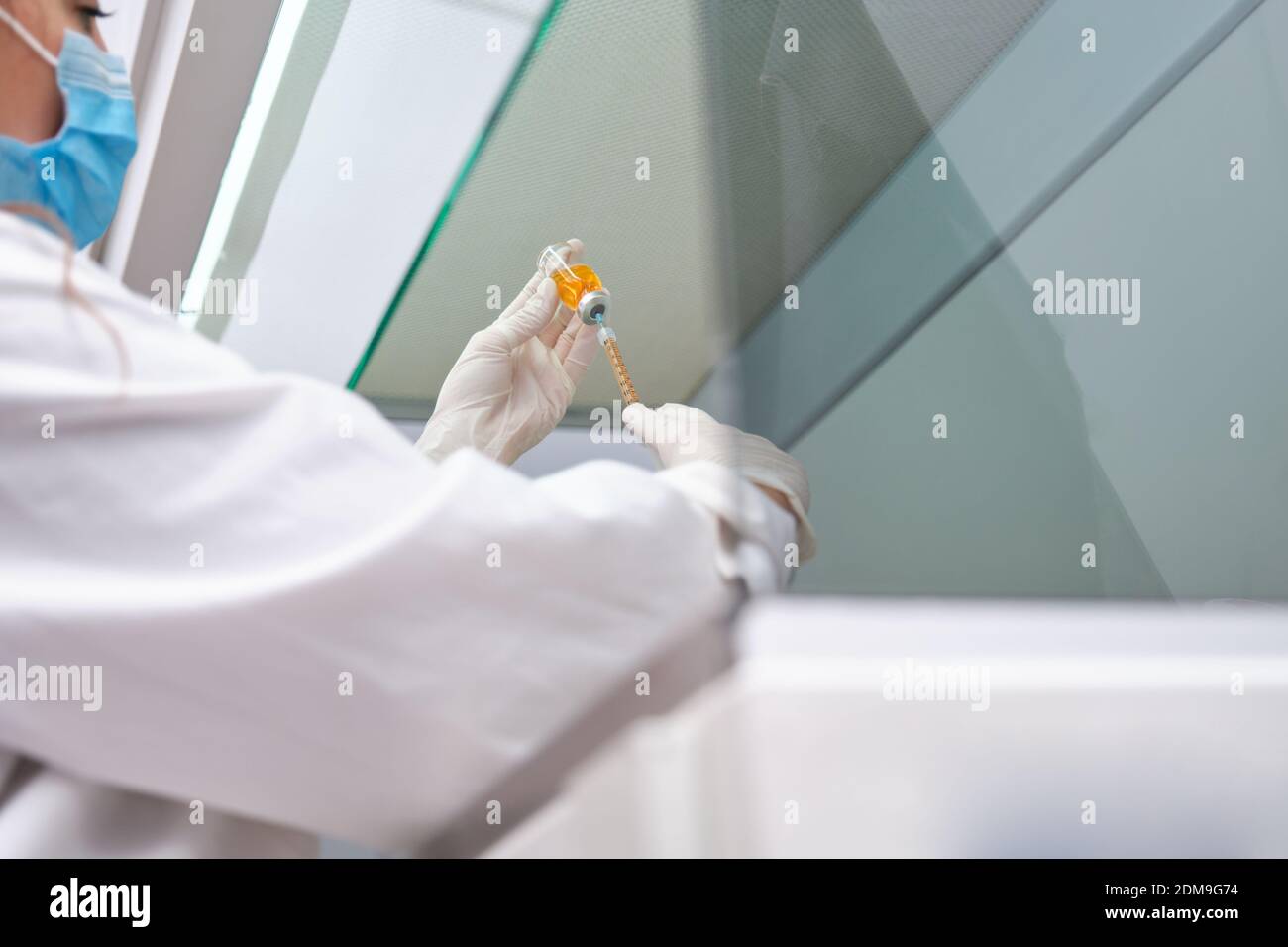 Unrecognizable scientist holding a coronavirus vaccine vial, syringe ...
