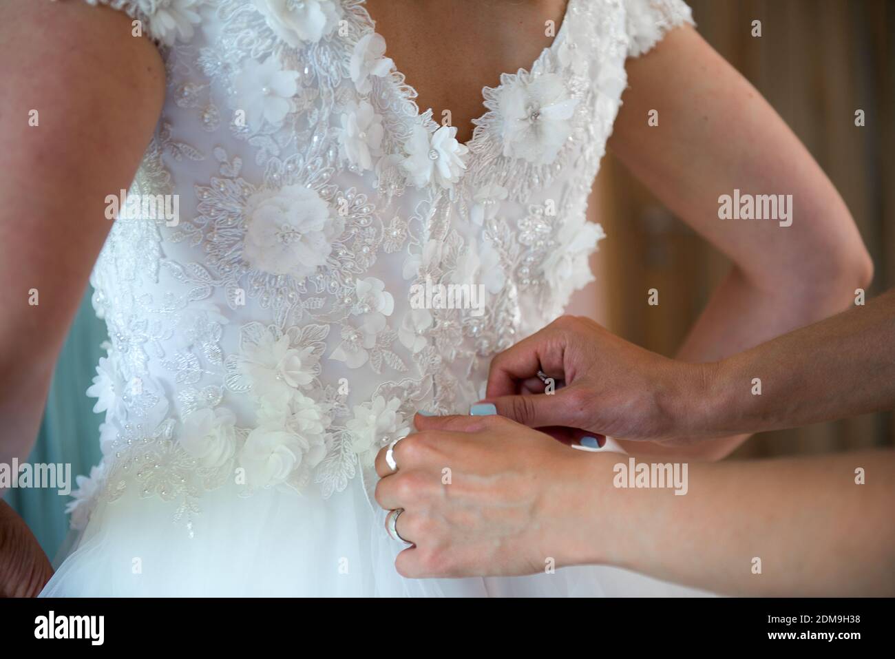 Woman helping bride dressed hi-res stock photography and images - Alamy