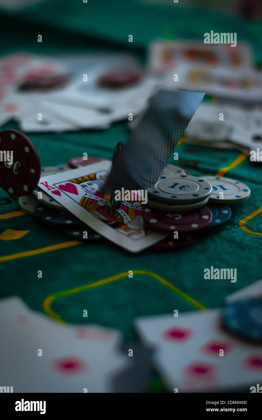 A vertical shot of a poker table with cards and poker chips with ...
