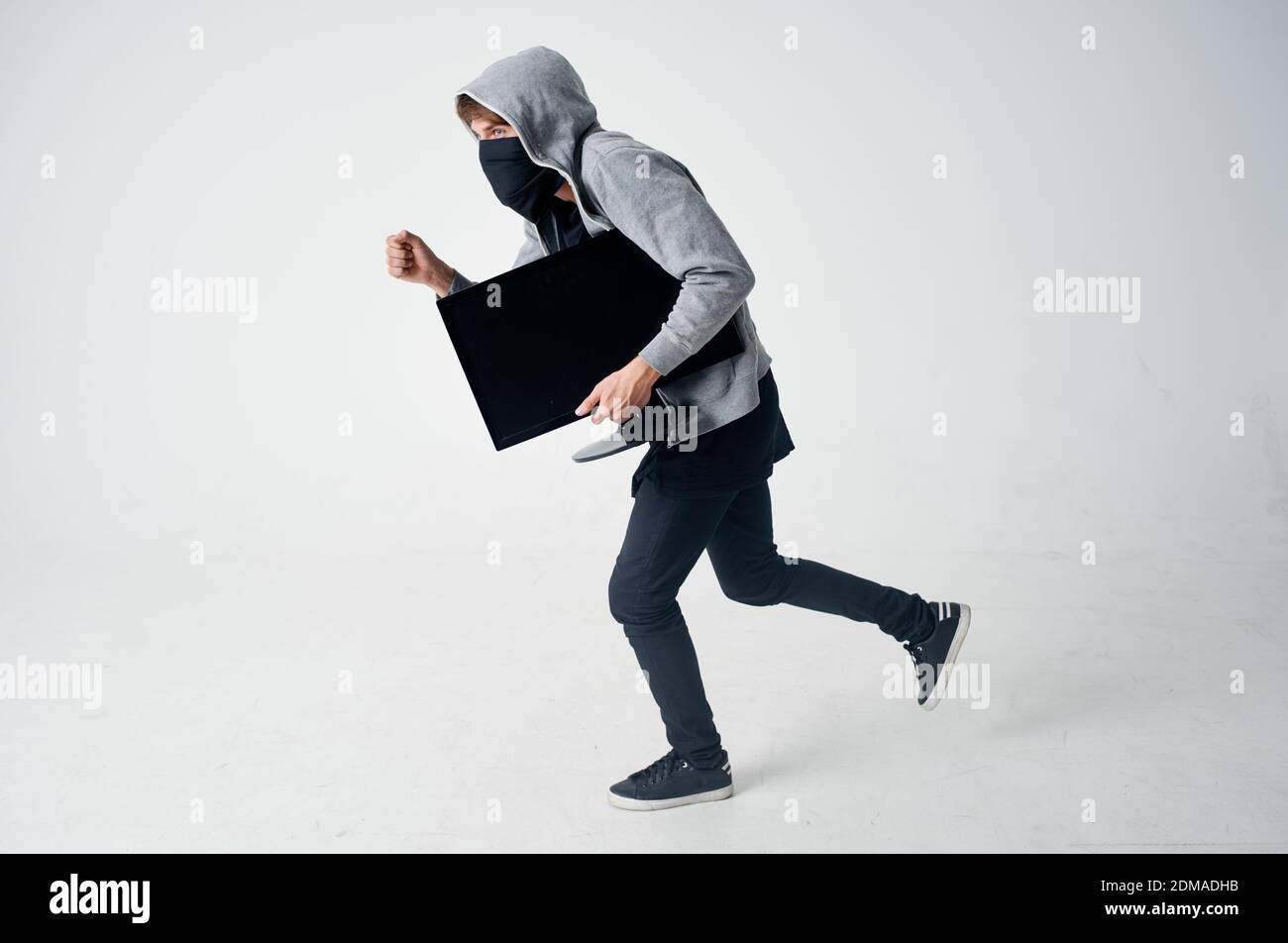 a man in a gray hoodie disguise theft technique hacker Stock Photo - Alamy