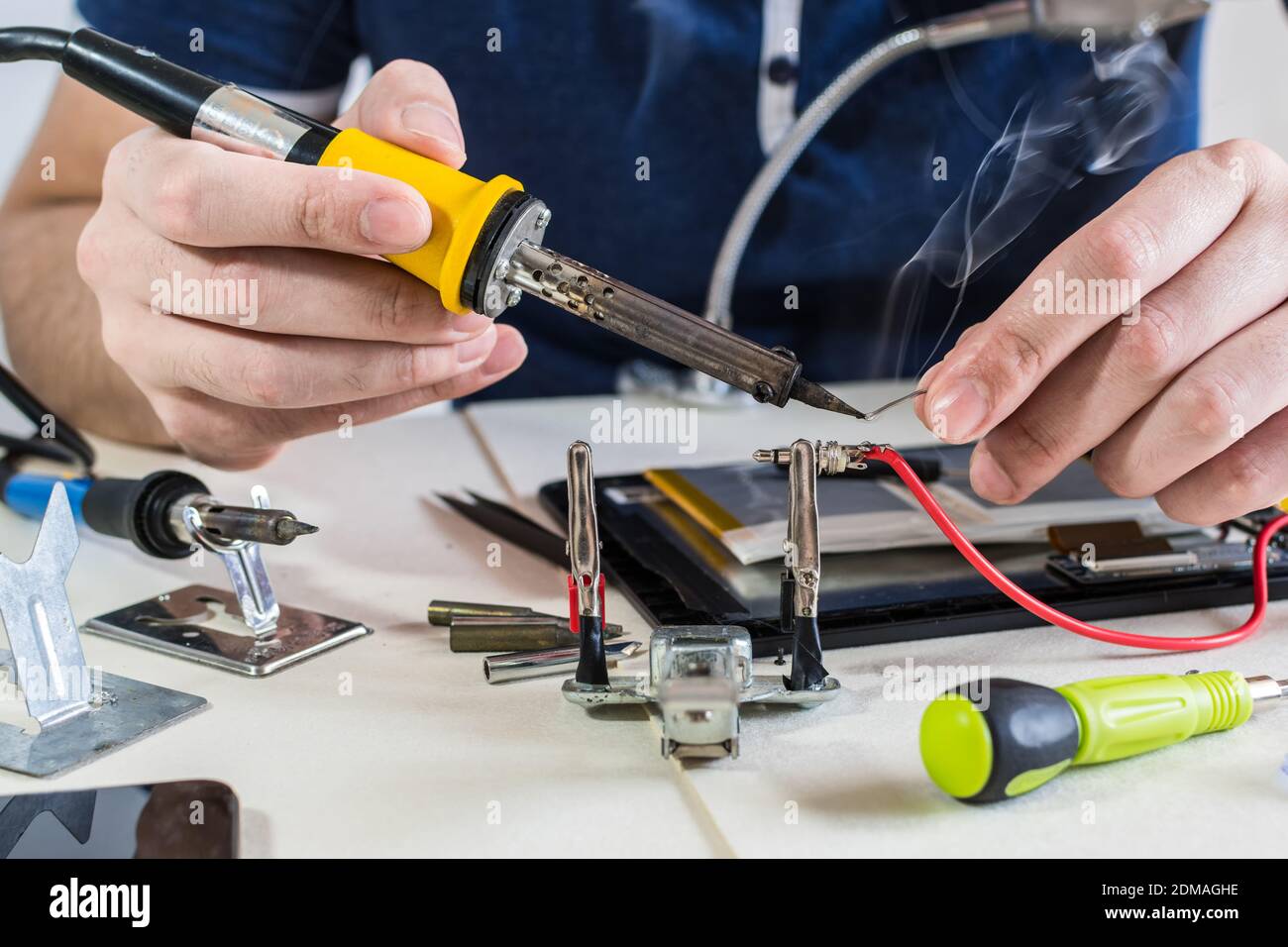 A horizontal shot of male hands soldering a cable to an electronic ...