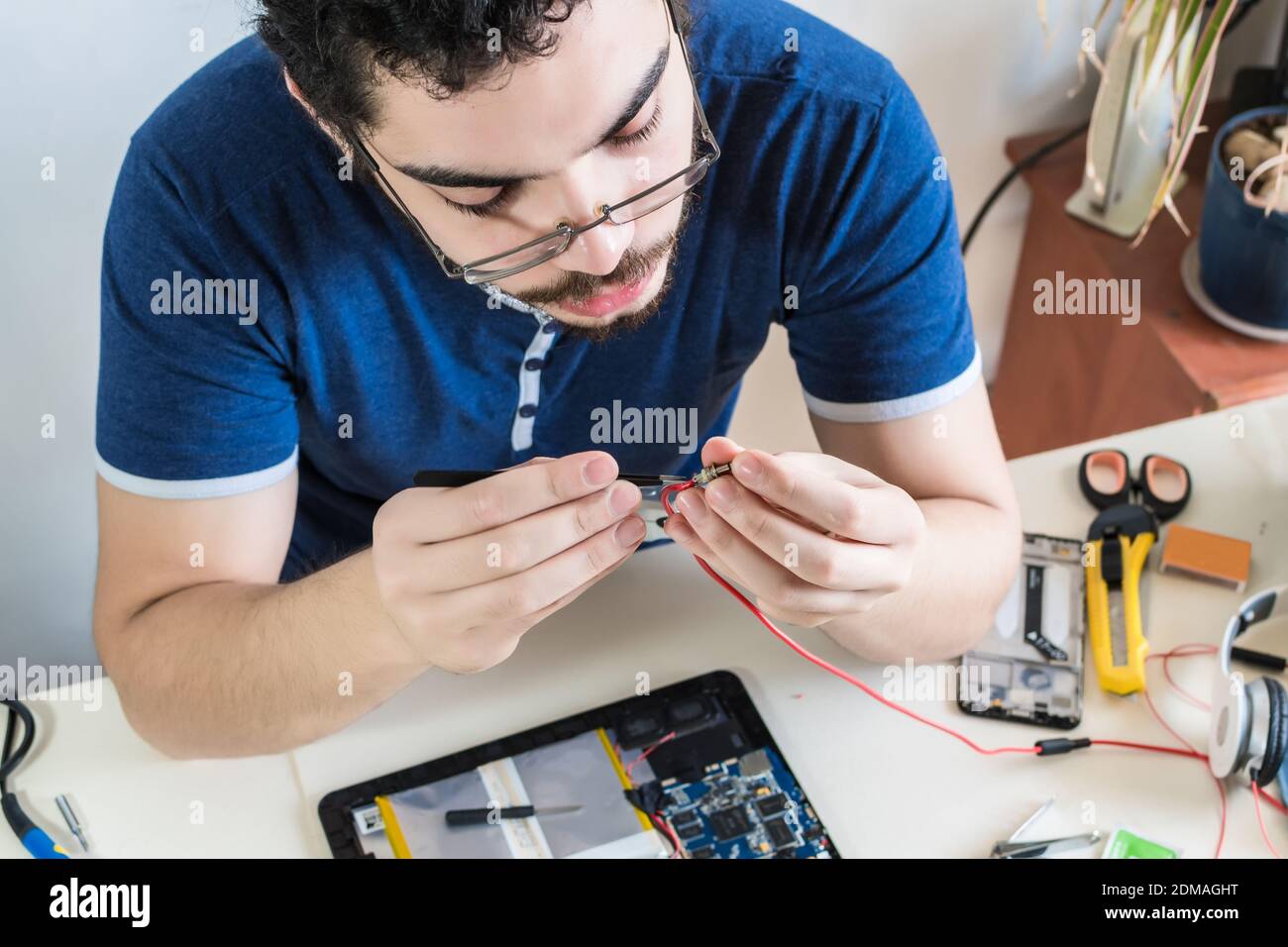 A computer repairman repairing the parts of the electronic device, a ...