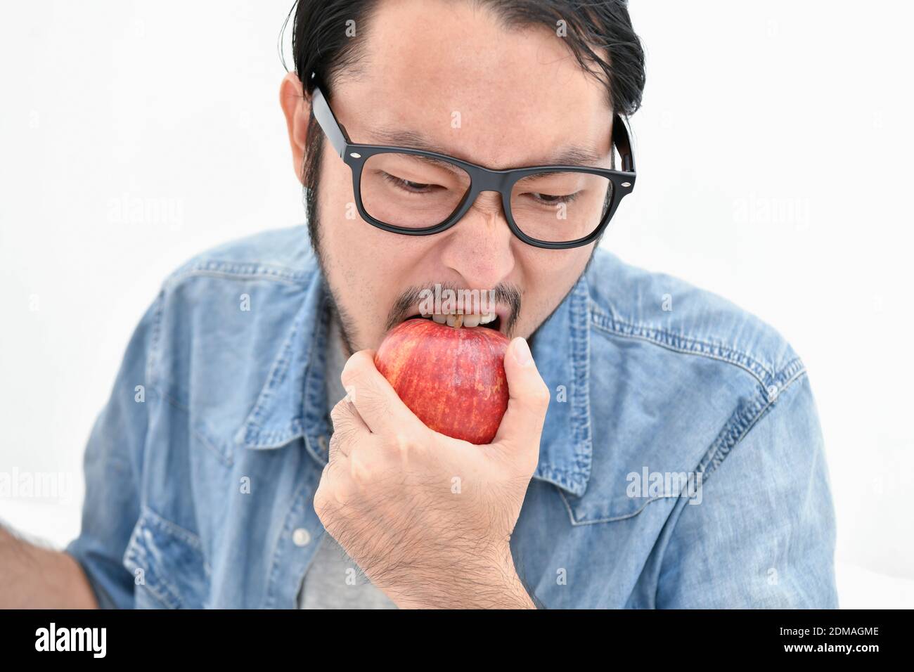 Young asian man eating apple hi-res stock photography and images - Alamy