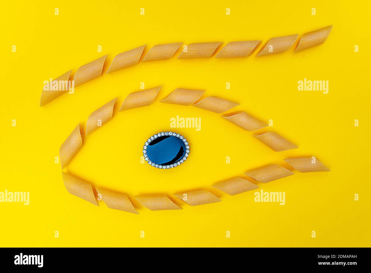 group of pasta lined up in the shape of an eye with a jewel in the ...