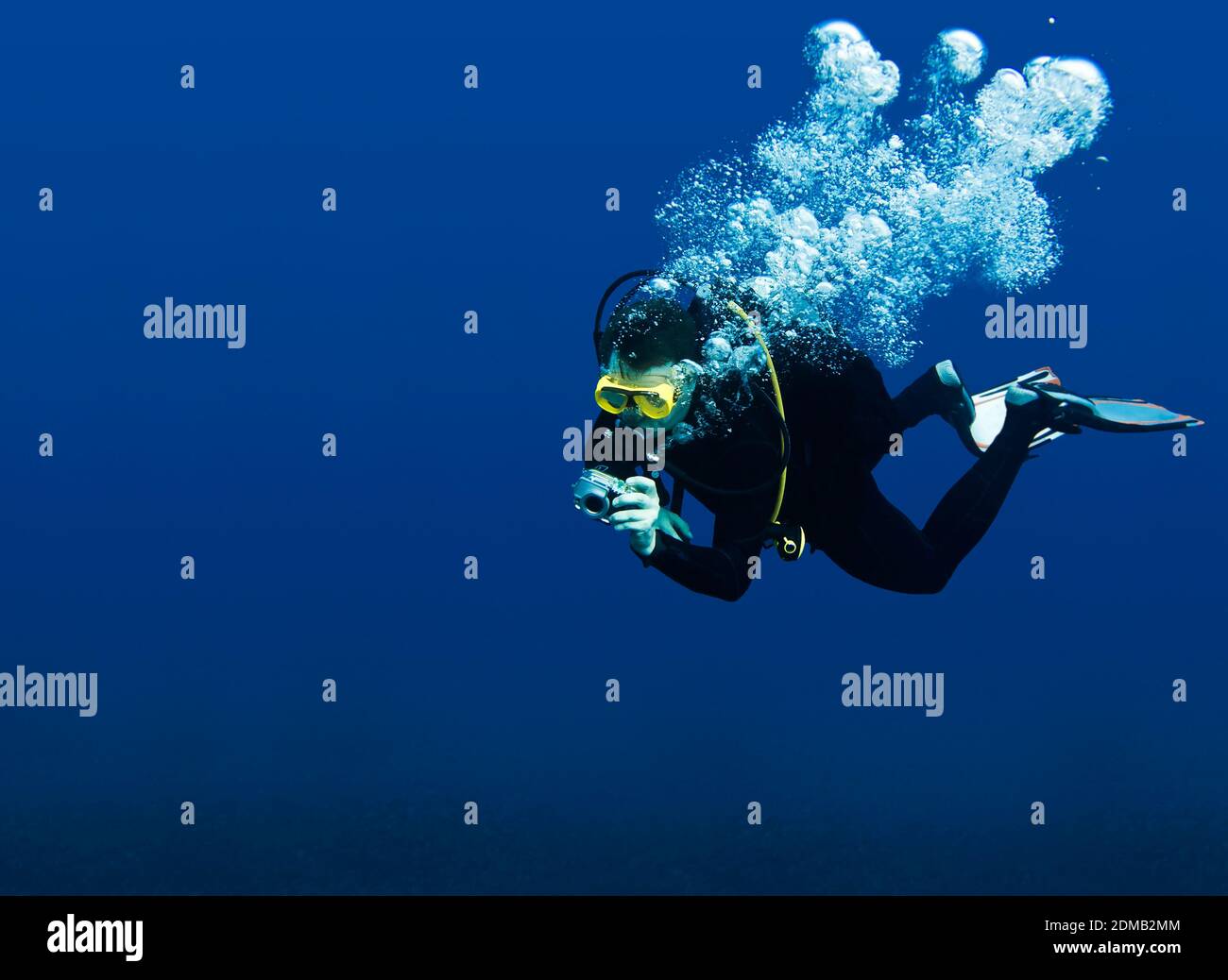 Recreational scuba diver with yellow mask, cloud of bubbles in black ...
