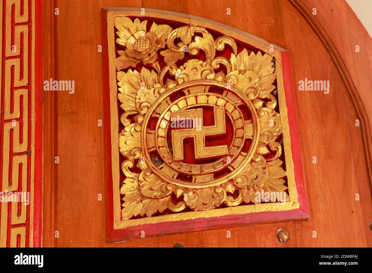 Gilded wooden carved Buddhist swastika. Carved ornament on the door in ...