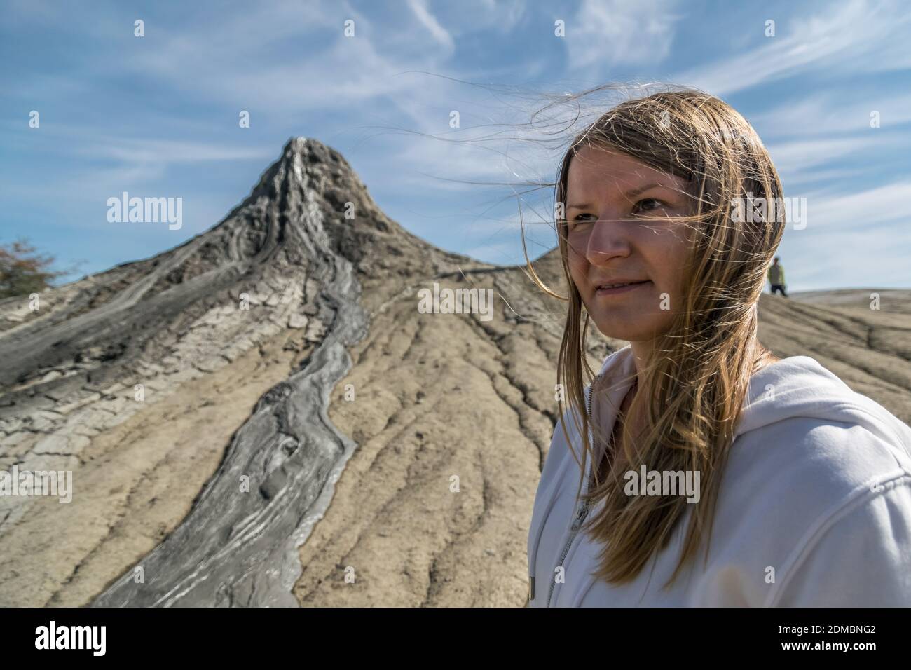 Young girl outdoors wearing sportswear with a mud volcano's crater in ...