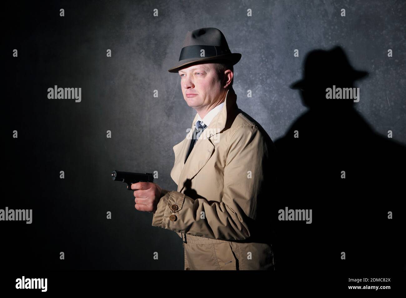Man Aiming Gun While Standing Against Wall Stock Photo - Alamy