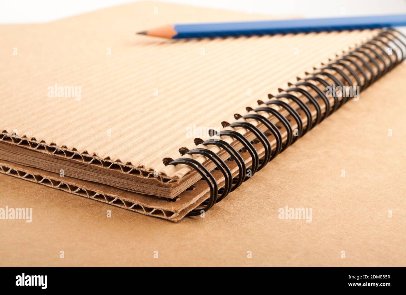 Notepad and blue pencil on cardboard background Stock Photo - Alamy
