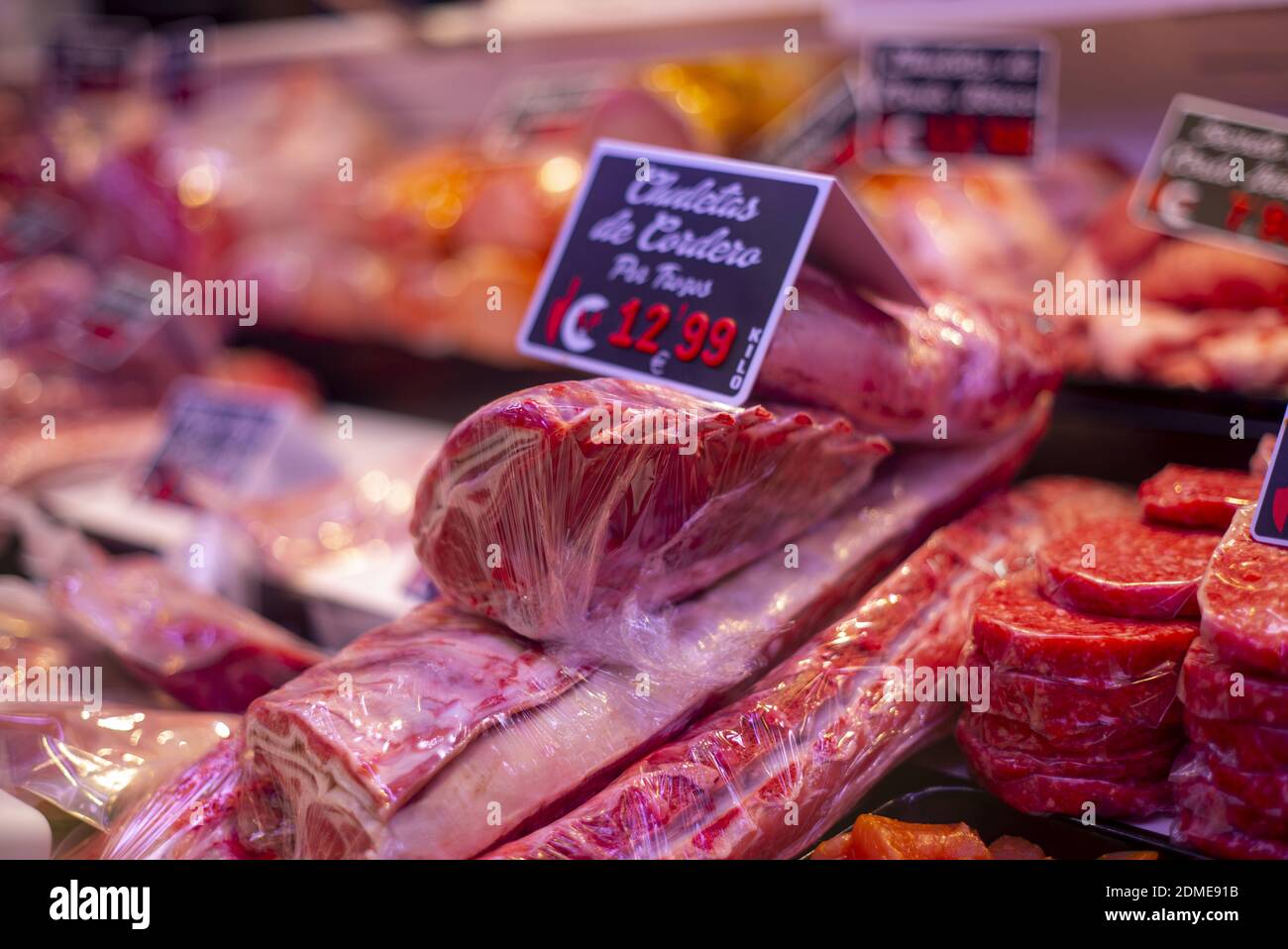 Fresh raw different meat slices on a butcher shop shelf with price tags ...