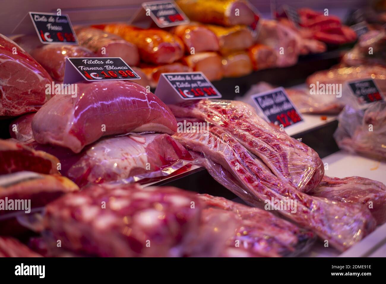 Fresh raw different meat slices on a butcher shop shelf with price tags ...