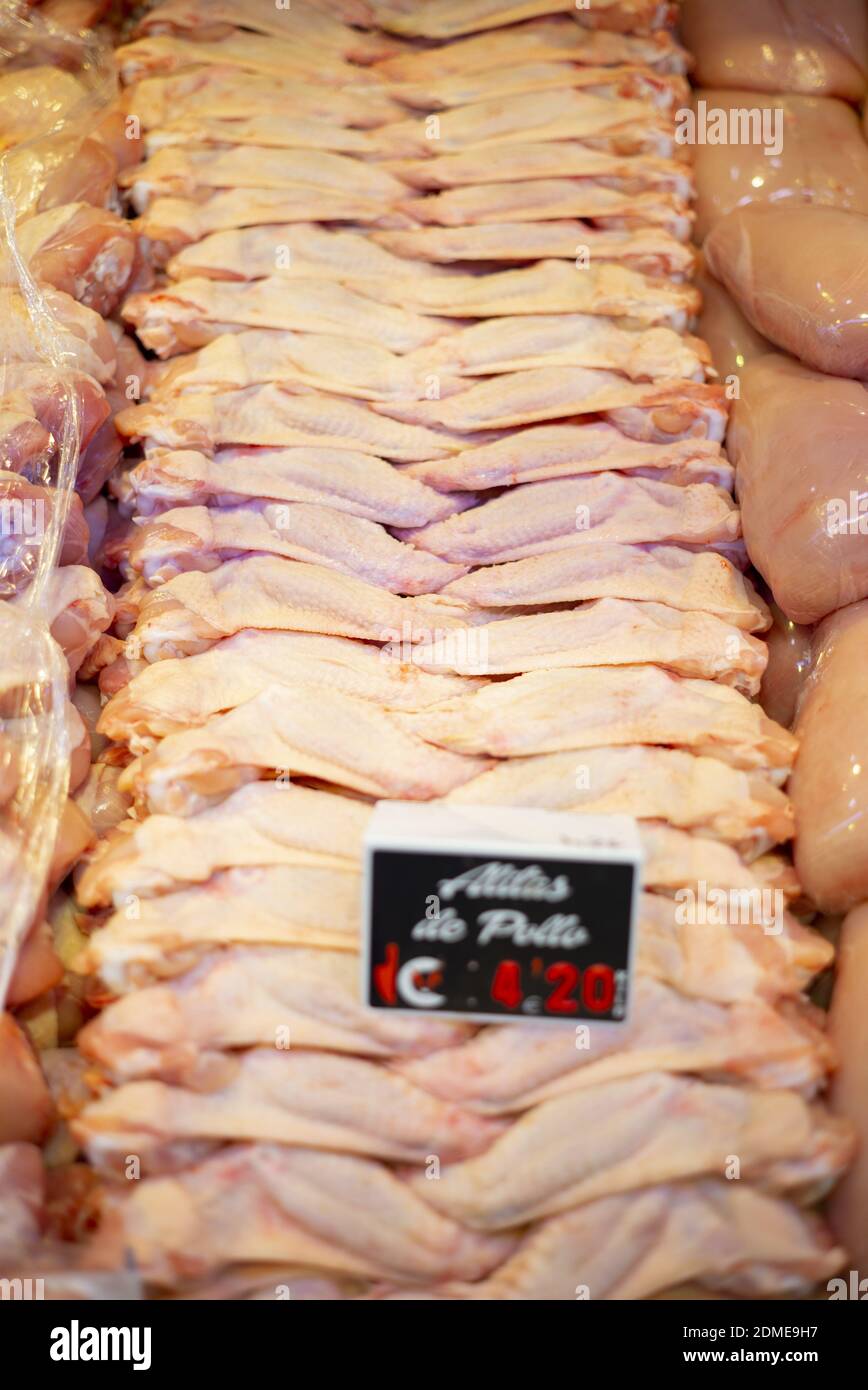 A vertical shot of raw fresh chicken meat slices on a display of a ...