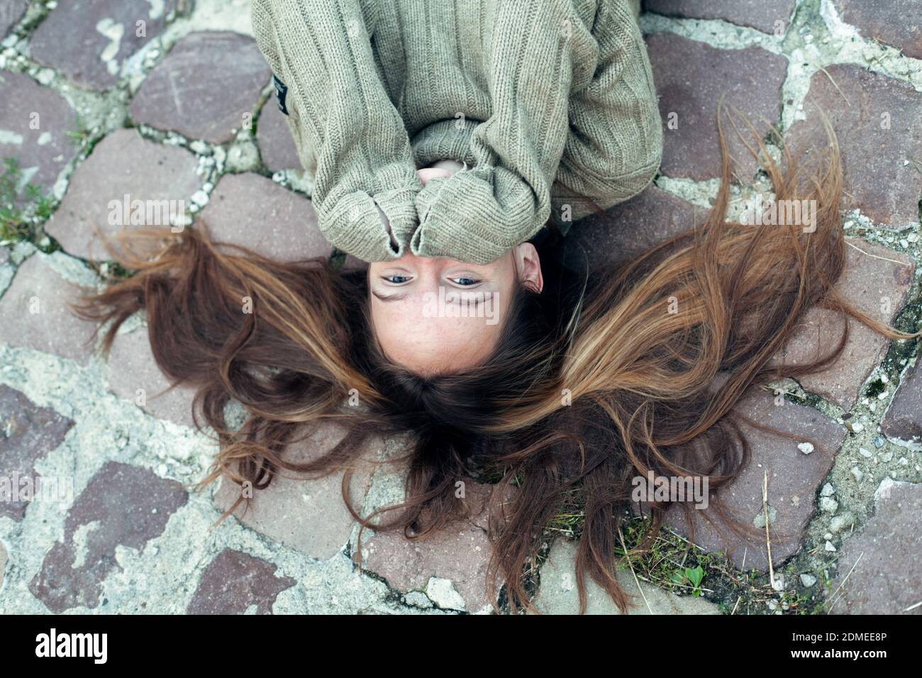 Teen girl lying on the stone pavement with scattered hair Stock Photo ...