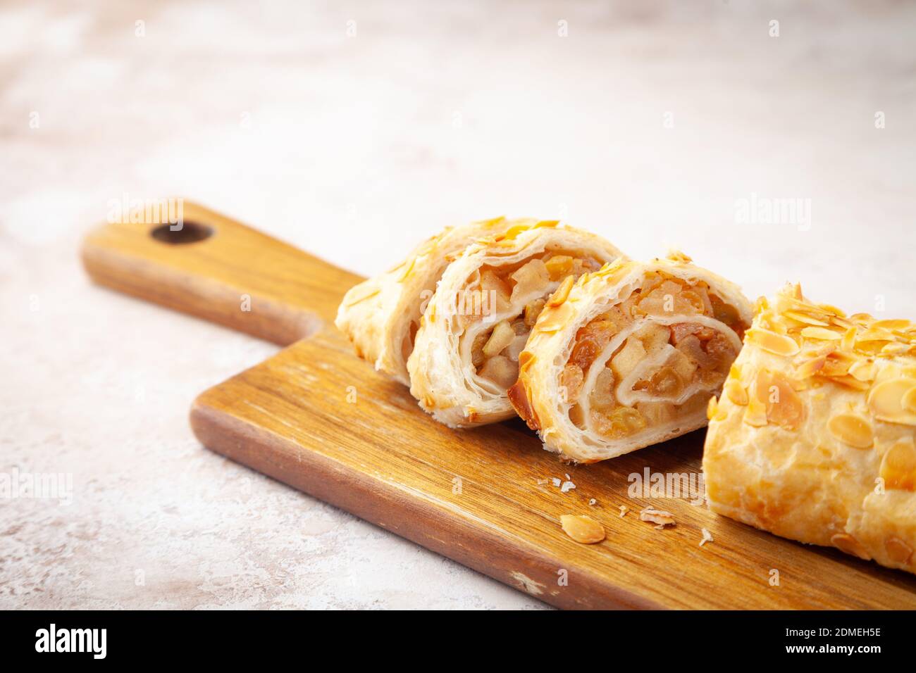 Baked biscuit swiss roll dessert with fruits and cream chopped on ...