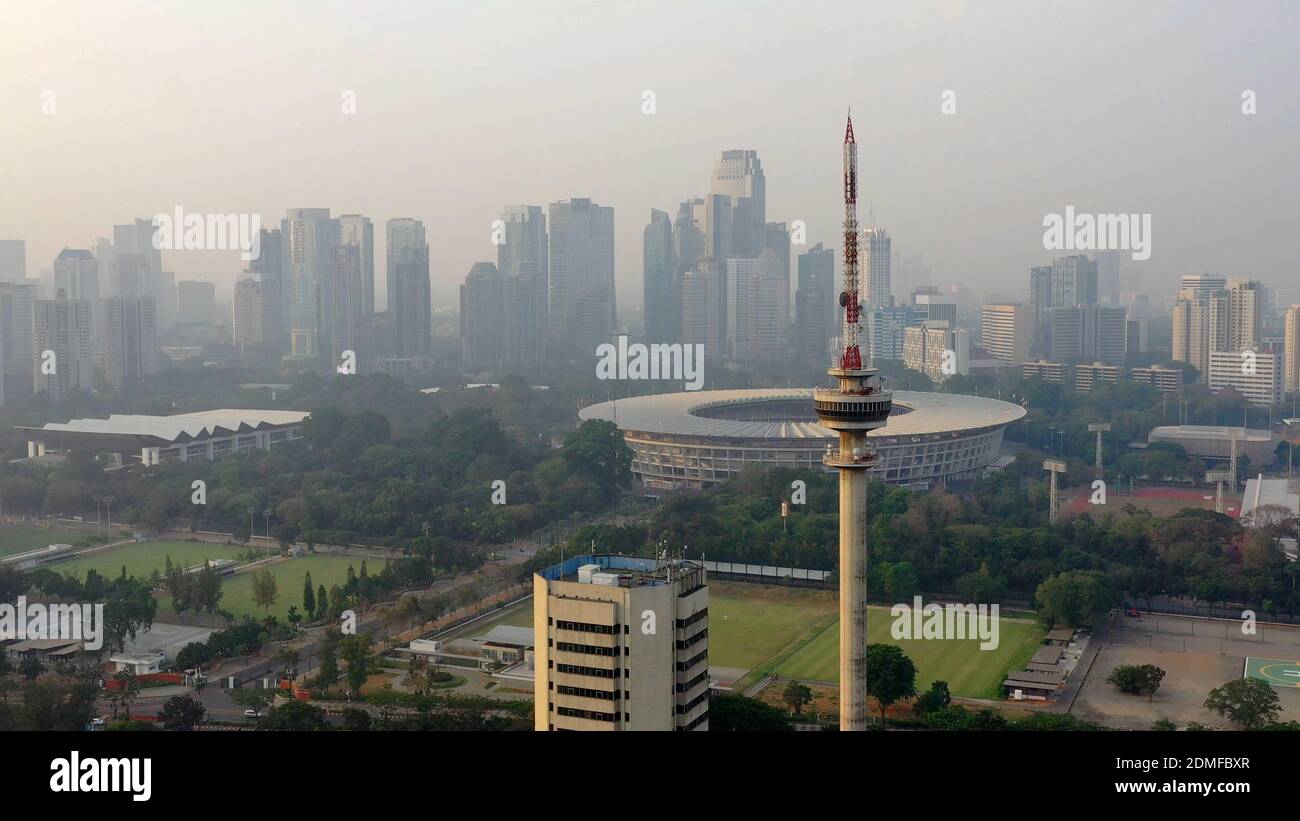 An aerial shot of a modern city with a sport stadium and some greenery ...