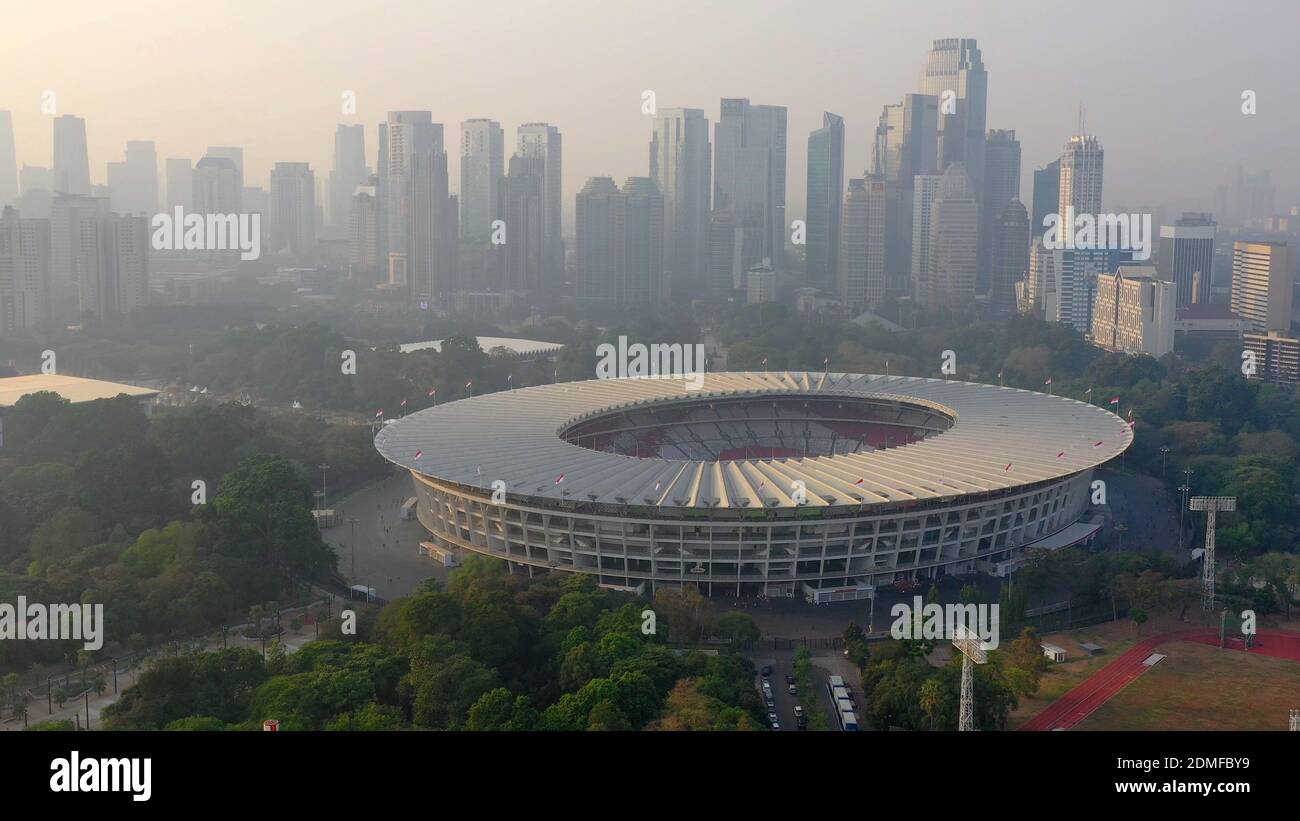 An aerial shot of a modern city with a sport stadium and some greenery ...