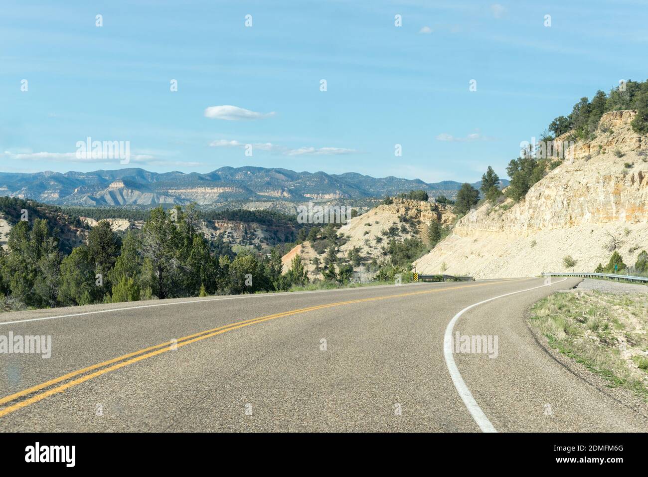 Lonely road between mountain ridges with some trees on each side of the ...
