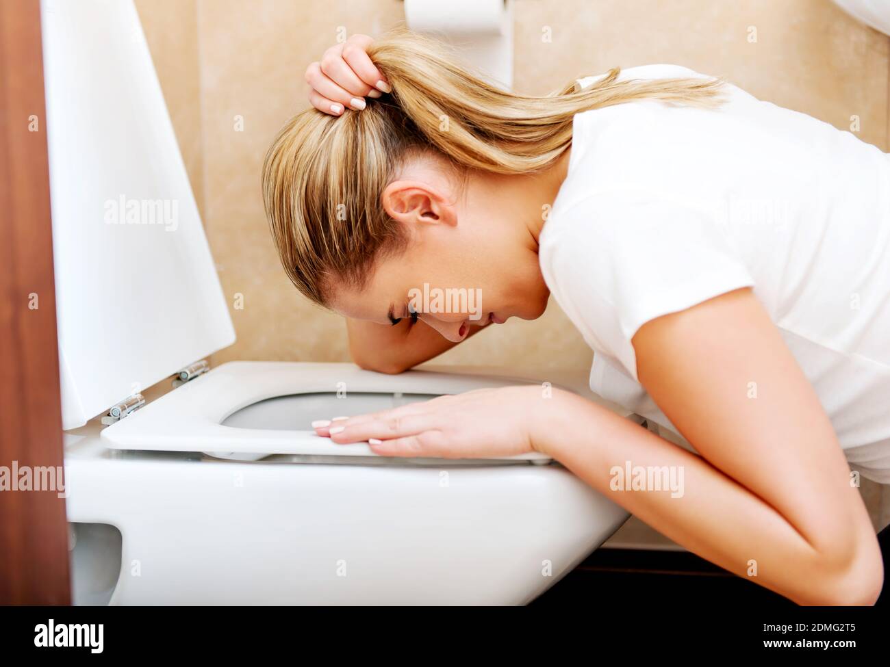 Woman vomiting into toilet hi-res stock photography and images - Alamy