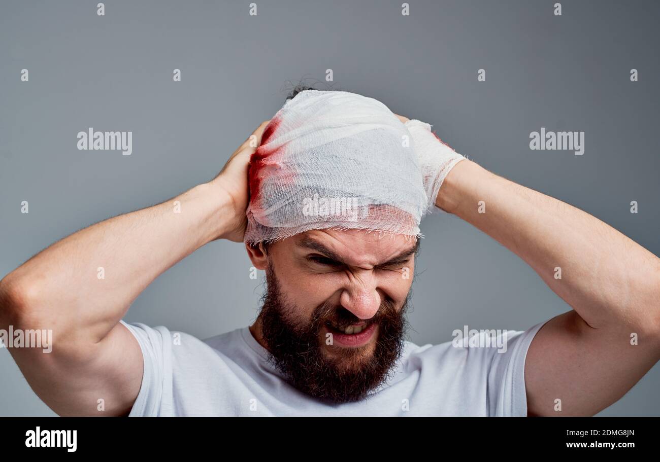 a man in intensive care bandaged head blood on his arm concussion Stock ...
