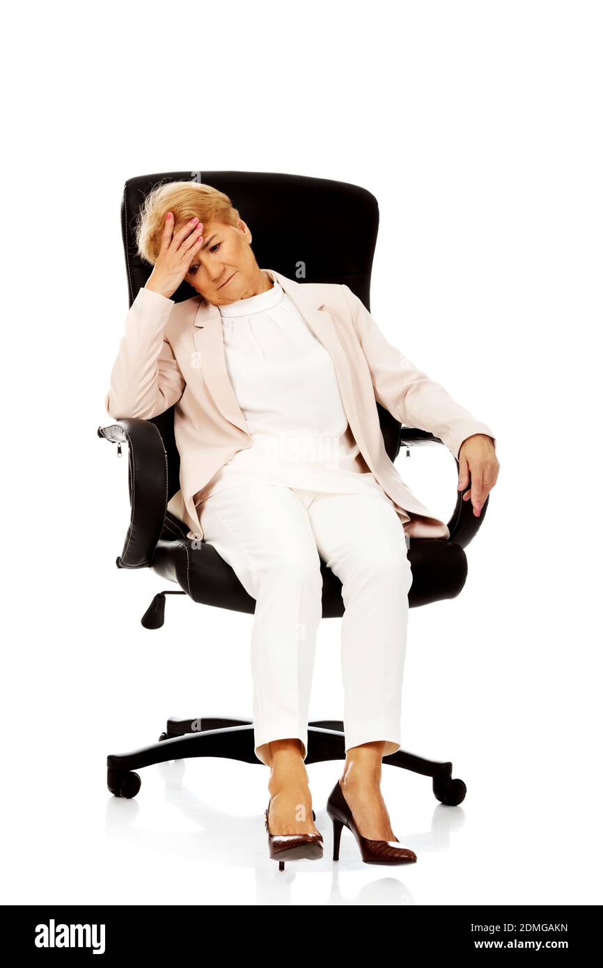 Stressed Senior Businesswoman Sitting On Chair Against White Background ...