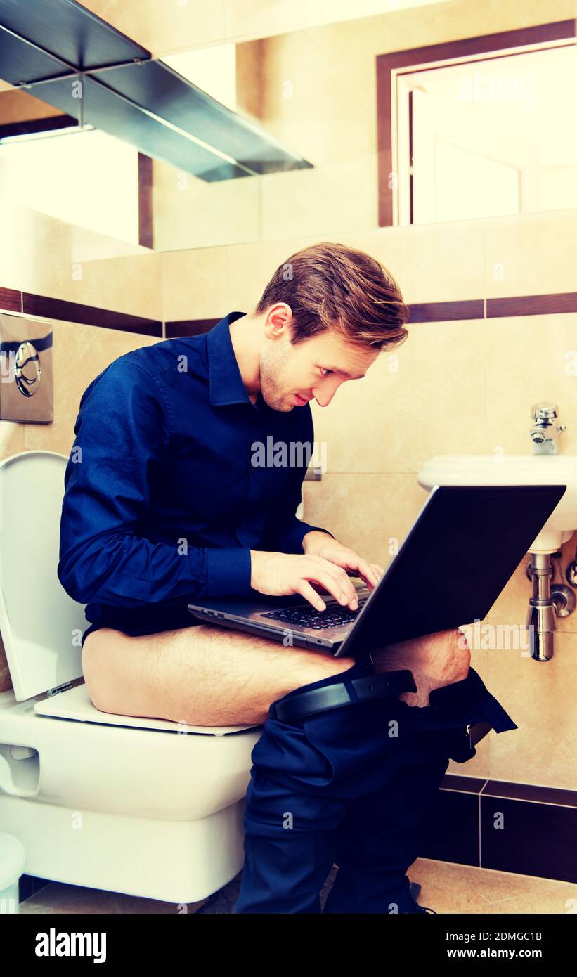 Man sitting on toilet using hi-res stock photography and images - Alamy